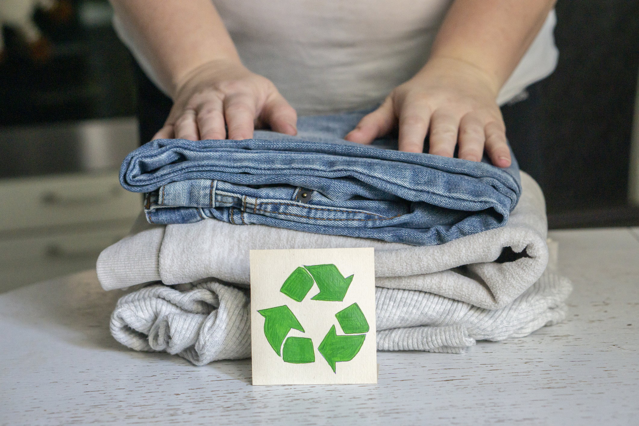 Garment recycling concept. A stack of clothes is on the recycling table ...